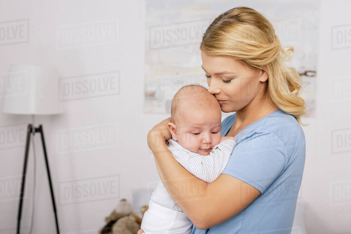 Portrait of sensual mother holding baby in hands at home - Royalty-free ...