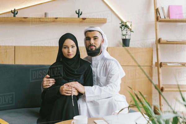 muslim couple sitting on couch and embracing - Royalty-free Stock Photo ...