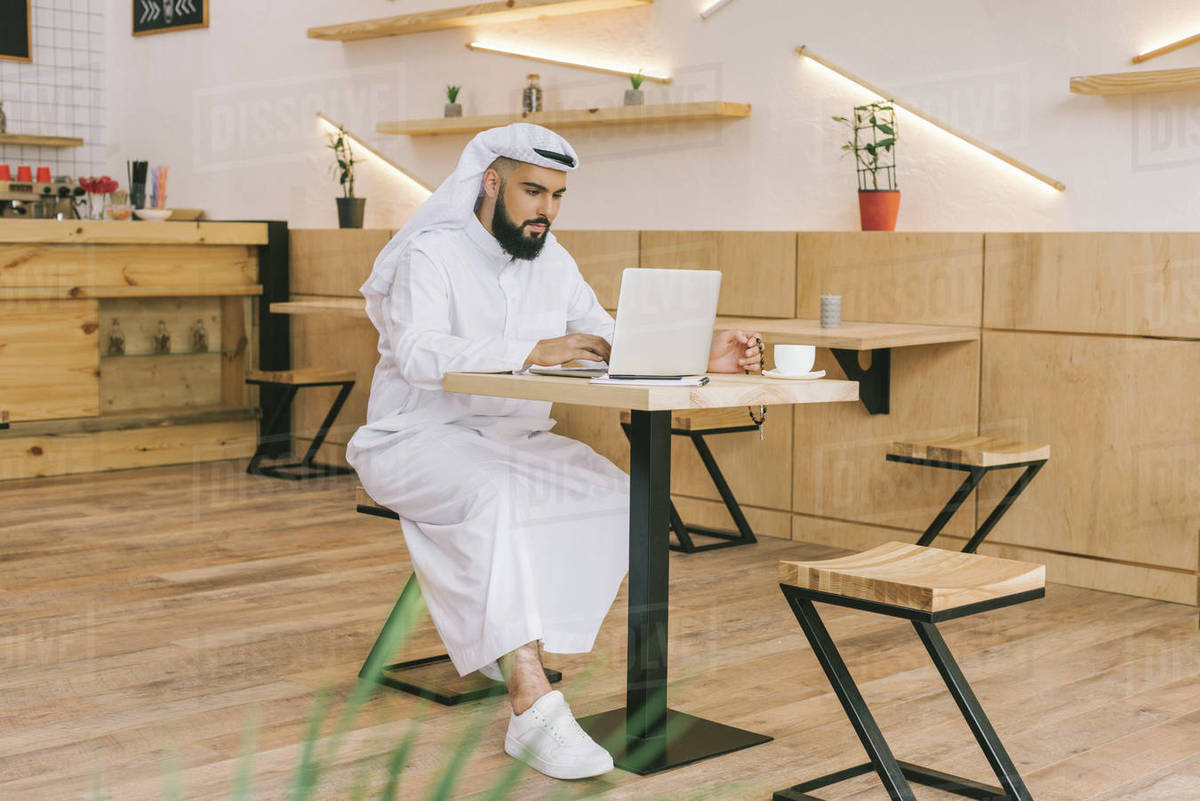handsome muslim man using laptop in cafe - Royalty-free Stock Photo ...