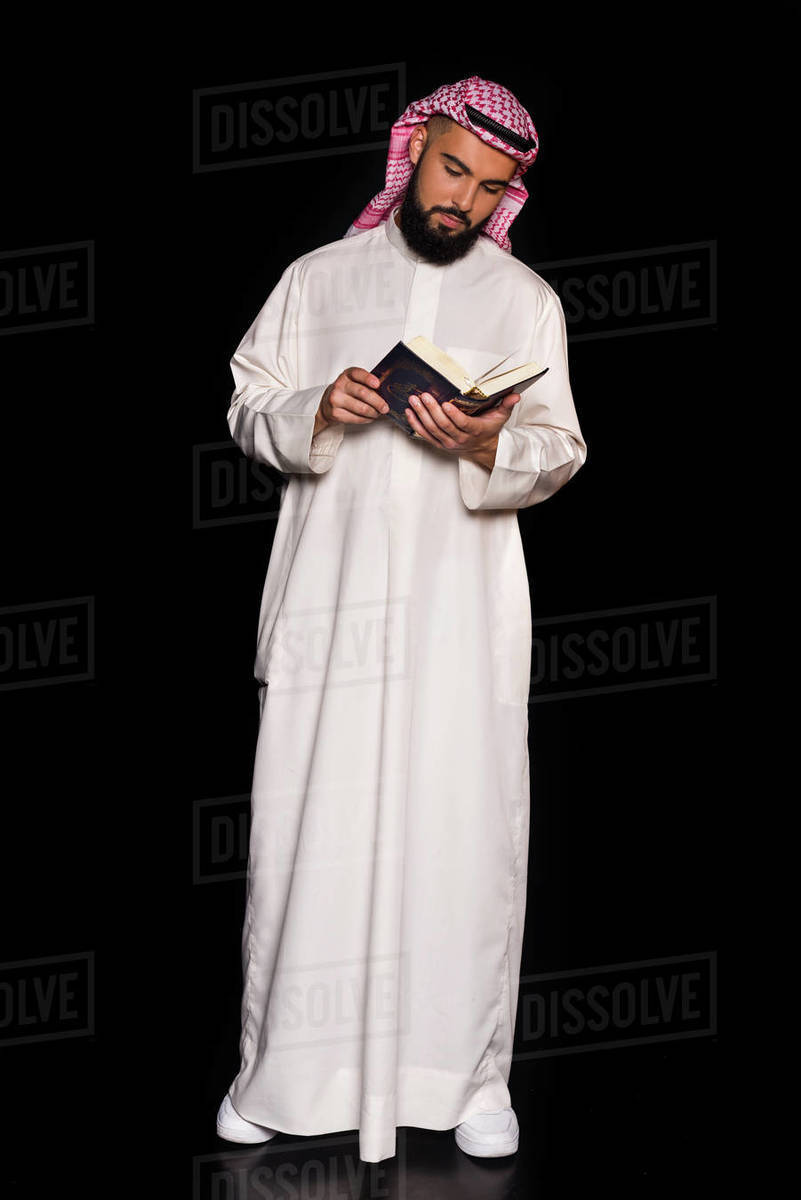 handsome muslim man reading quran isolated on black - Royalty-free ...