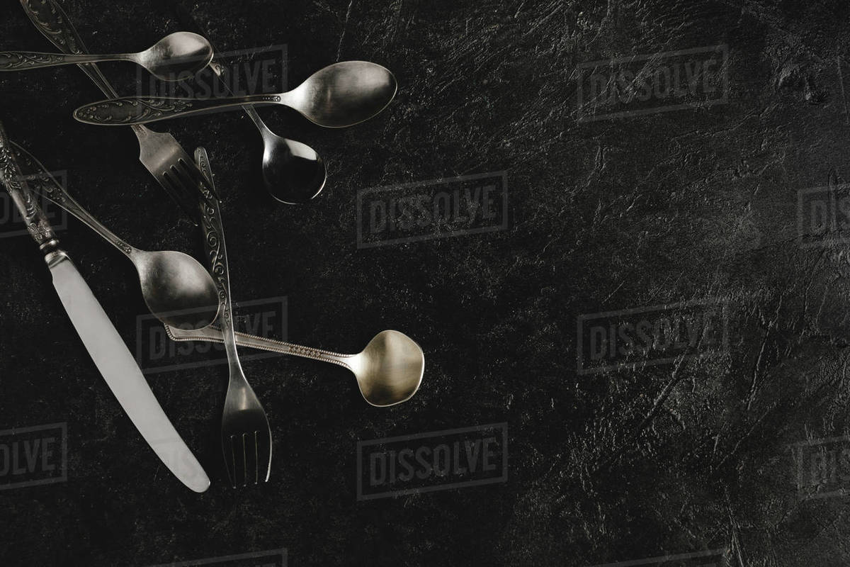 Top view of set of vintage silverware isolated on black table - Royalty ...