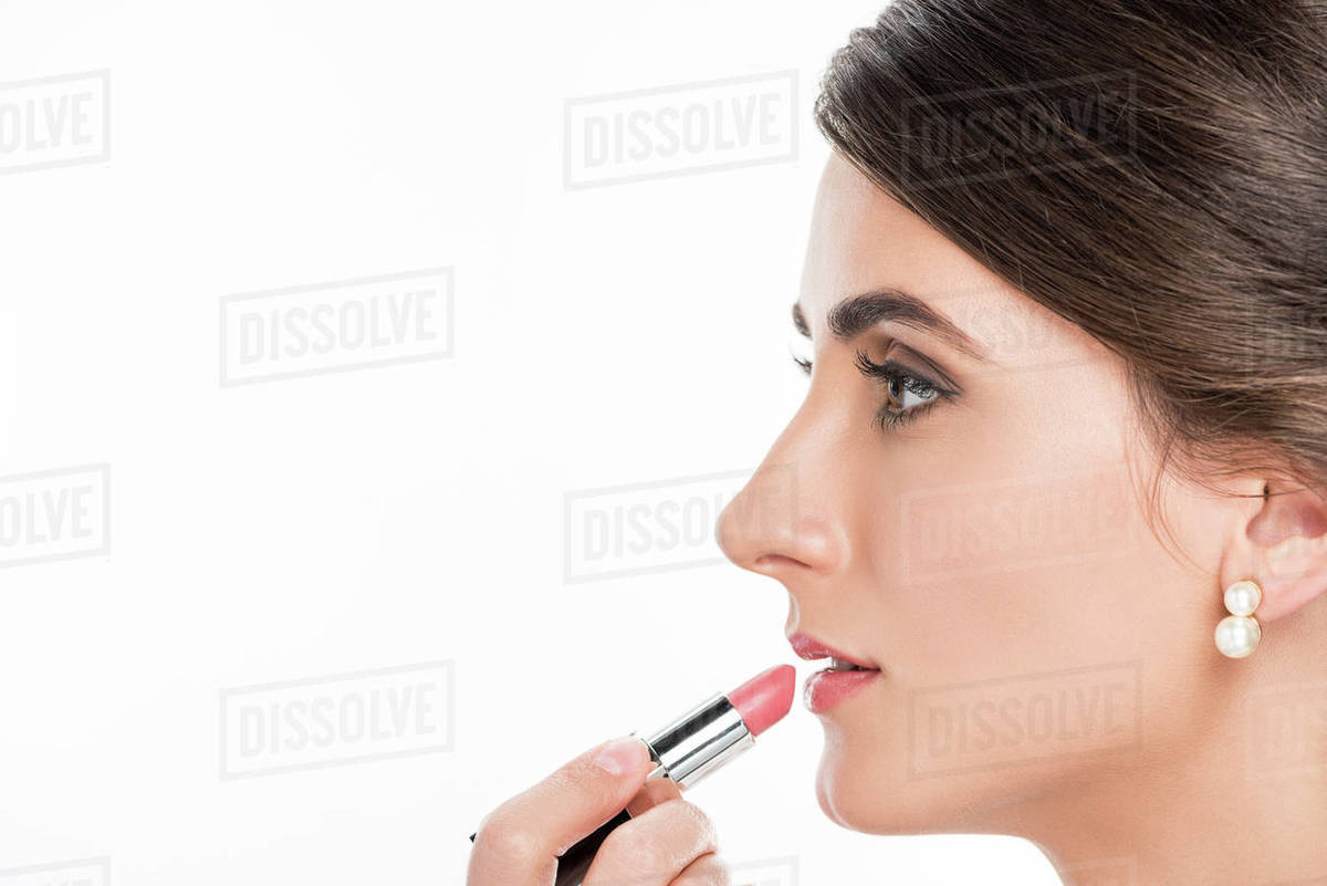 Side view of makeup artist applying lipstick on models lips isolated on ...