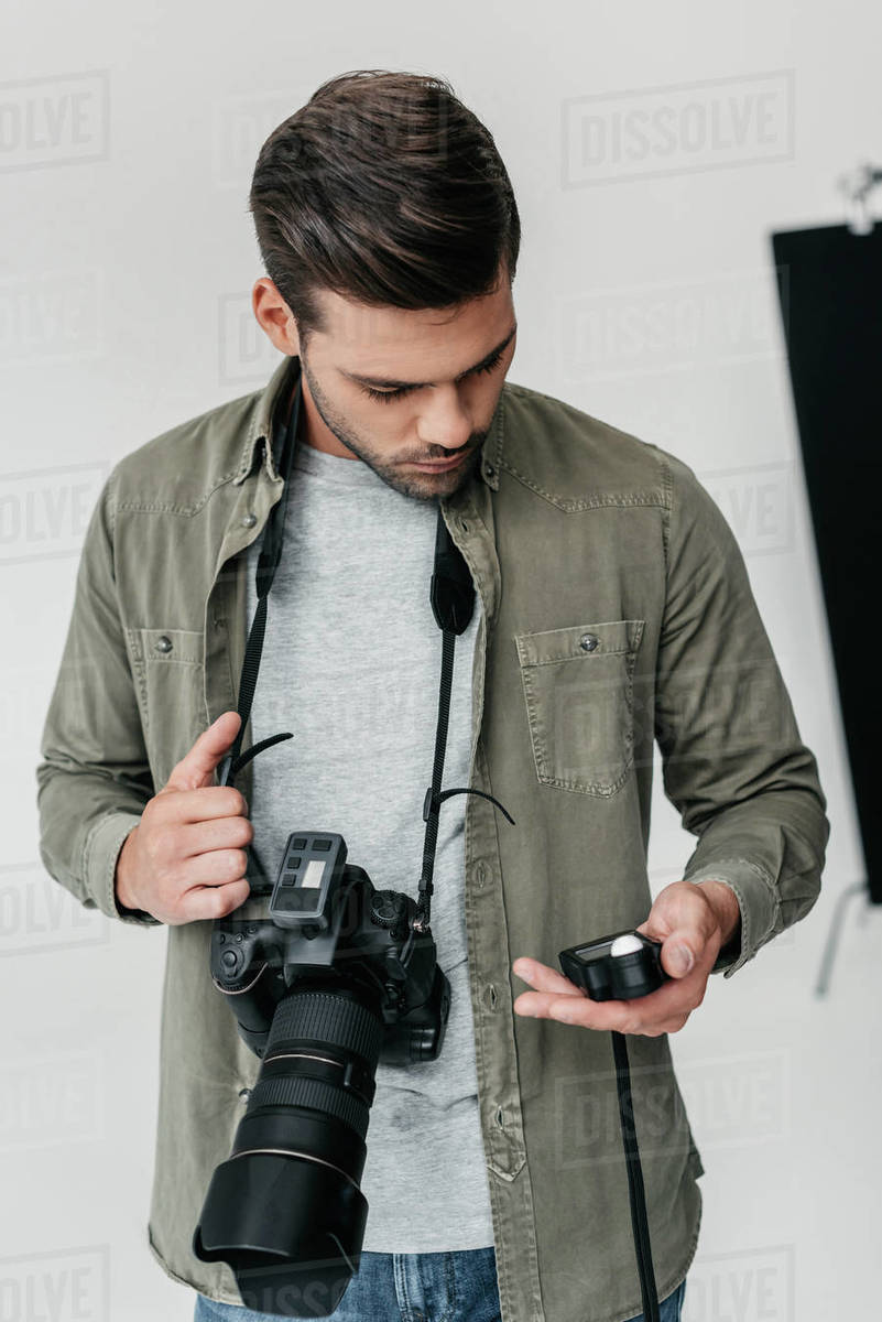 professional male photographer with digital photo camera and light ...