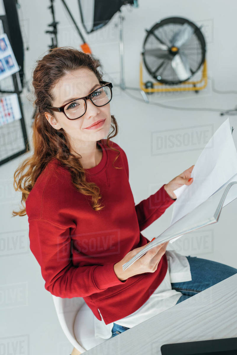 beautiful female designer reading magazine in modern office - Royalty ...