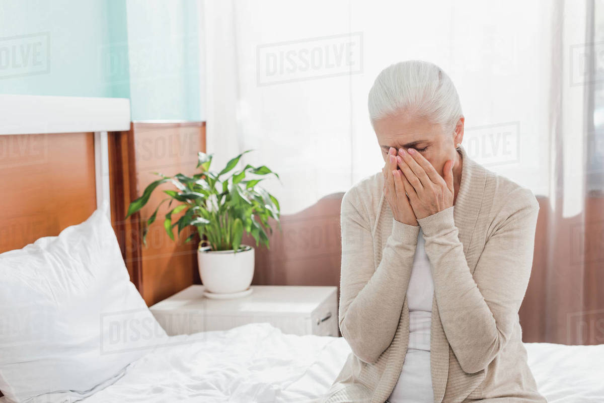 upset senior woman crying while sitting on hospital bed - Royalty-free ...