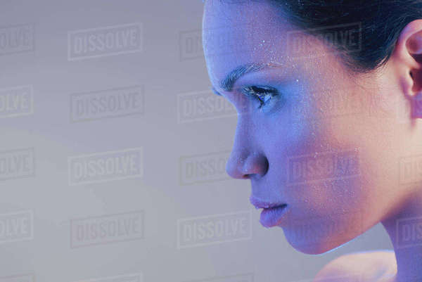 Side view shot of young woman with natural makeup and face covered in ...