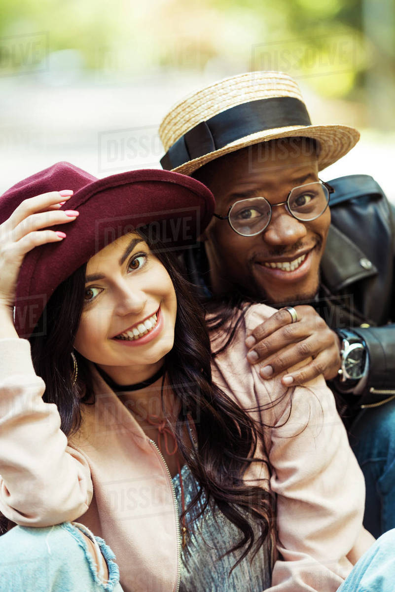 Portrait of smiling multicultural couple in hats - Royalty-free Stock ...