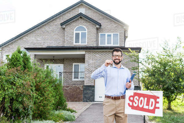 Handsome smiling realtor with keys of sold house - Royalty-free Stock ...