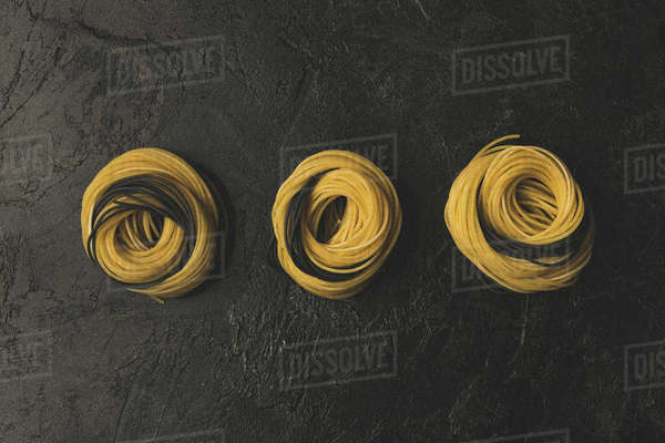 Top view of row of rolled pasta nests - Stock Photo - Dissolve