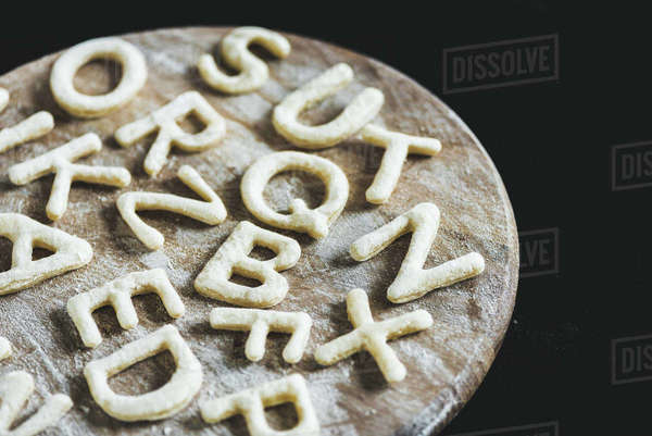 Close up view of letters made from cookie dough on wooden board with ...