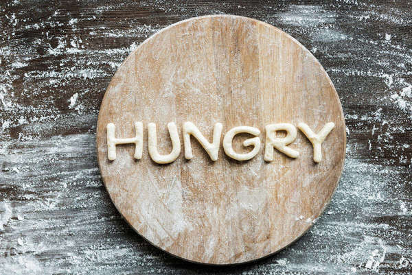 Top view of word hungry made from cookie dough with flour on wooden ...