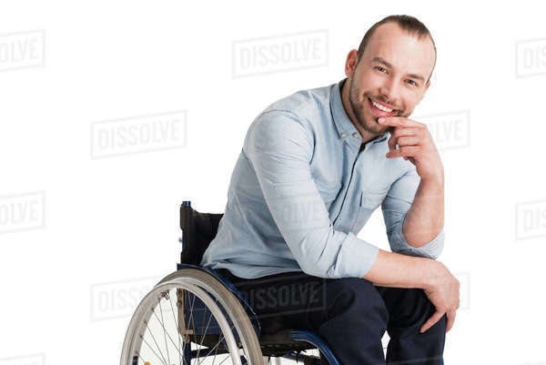Smiling disabled man in wheelchair posing with hand on chin and looking ...