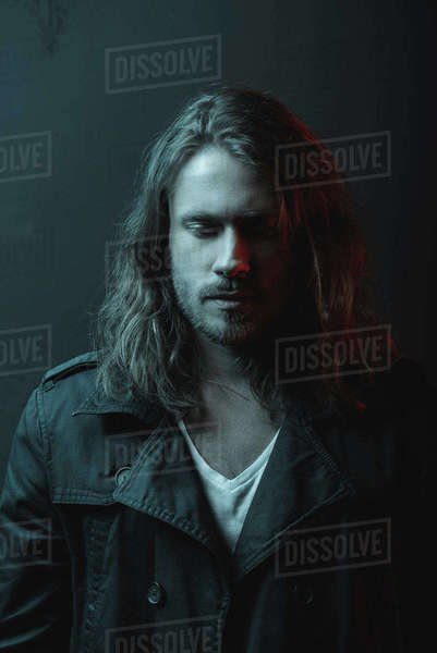 Portrait of handsome stylish bearded young man with long hair looking ...