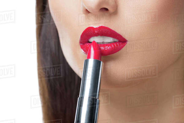 Close-up partial view of young woman applying red lipstick isolated on ...