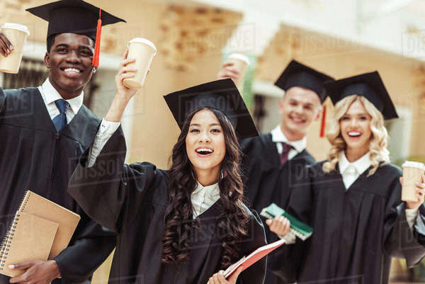 group of multiethnic graduated students with paper cups of coffee ...