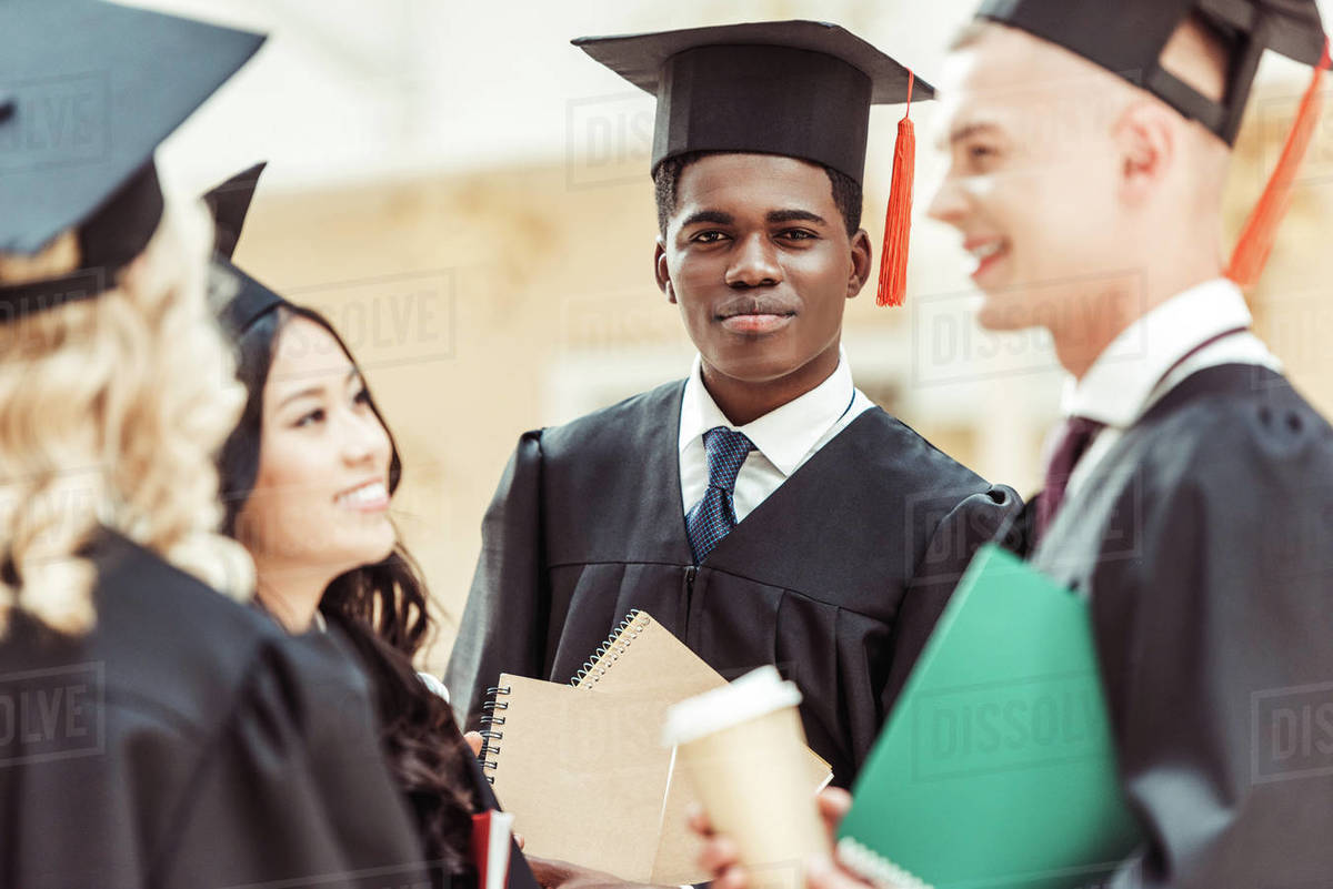 group of happy graduated multiethnic students spending time together ...