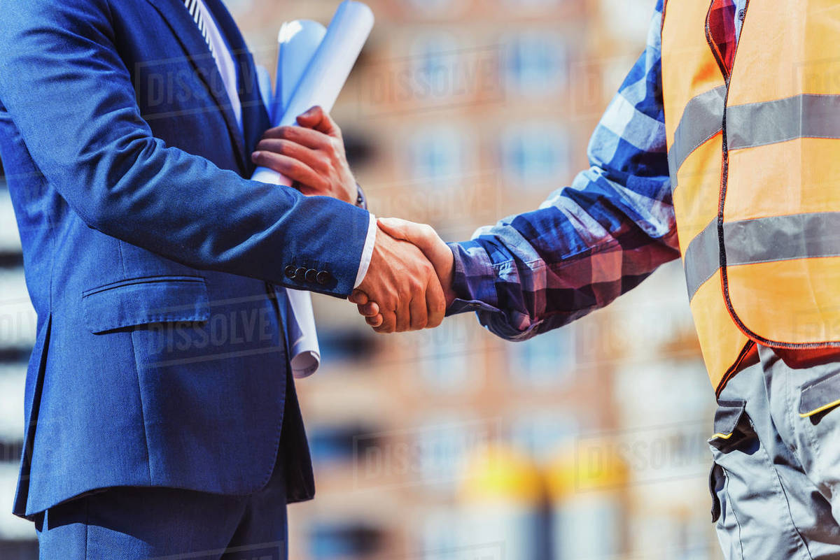 Cropped Shot Of Construction Worker In Reflective Vest Shaking Hands With Businessman Stock cropped-shot-of-construction-worker-in-reflective-vest-shaking-hands-with-businessman-stock