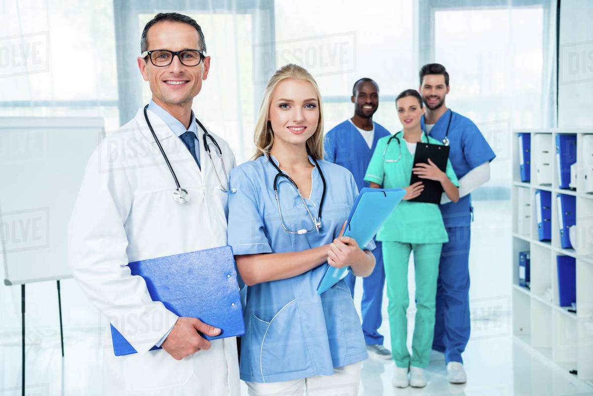 Group of multiethnic doctors in clinic looking at camera - Royalty-free ...