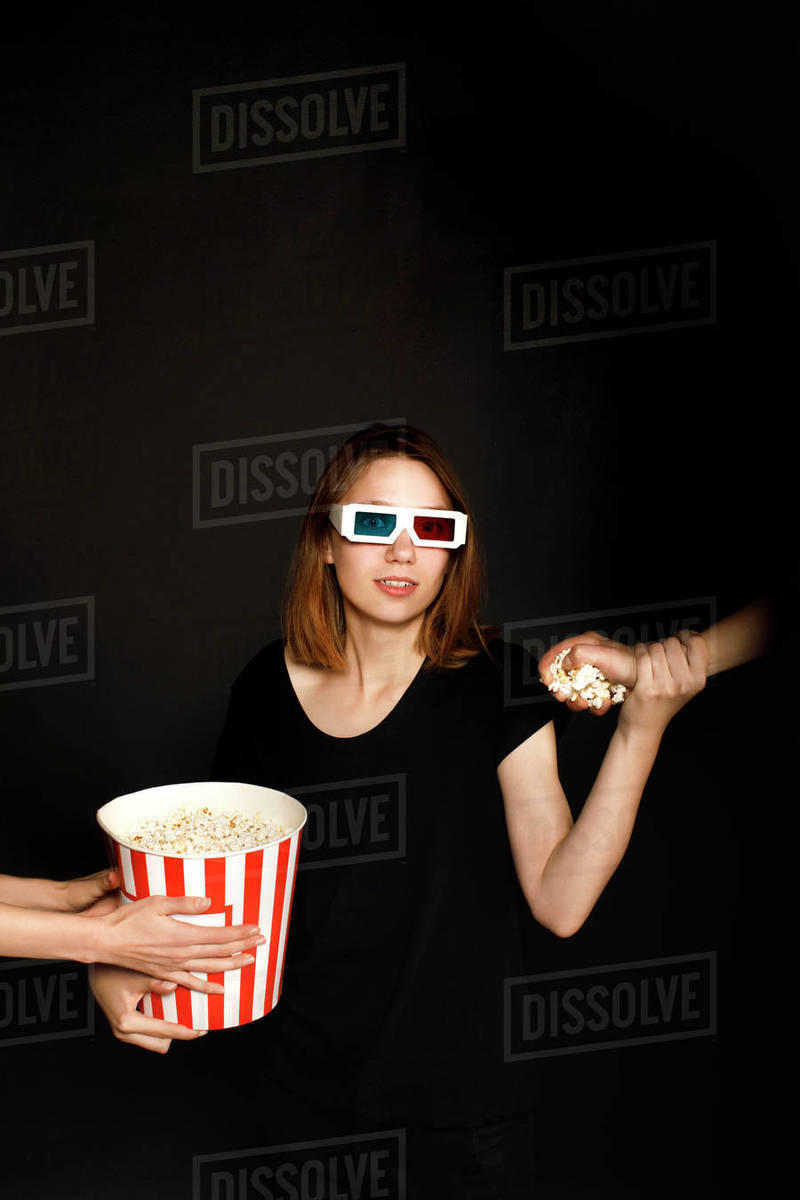 Woman with bucket of popcorn holding hand of thief at cinema isolated ...