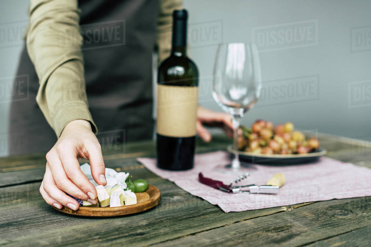 Female taster taking piece of brie cheese - Stock Photo - Dissolve