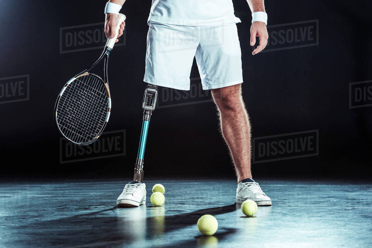 Cropped shot of tennis player holding tennis racket with tennis balls ...