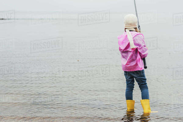 back view of lonely little girl fishing in sea - Royalty-free Stock ...