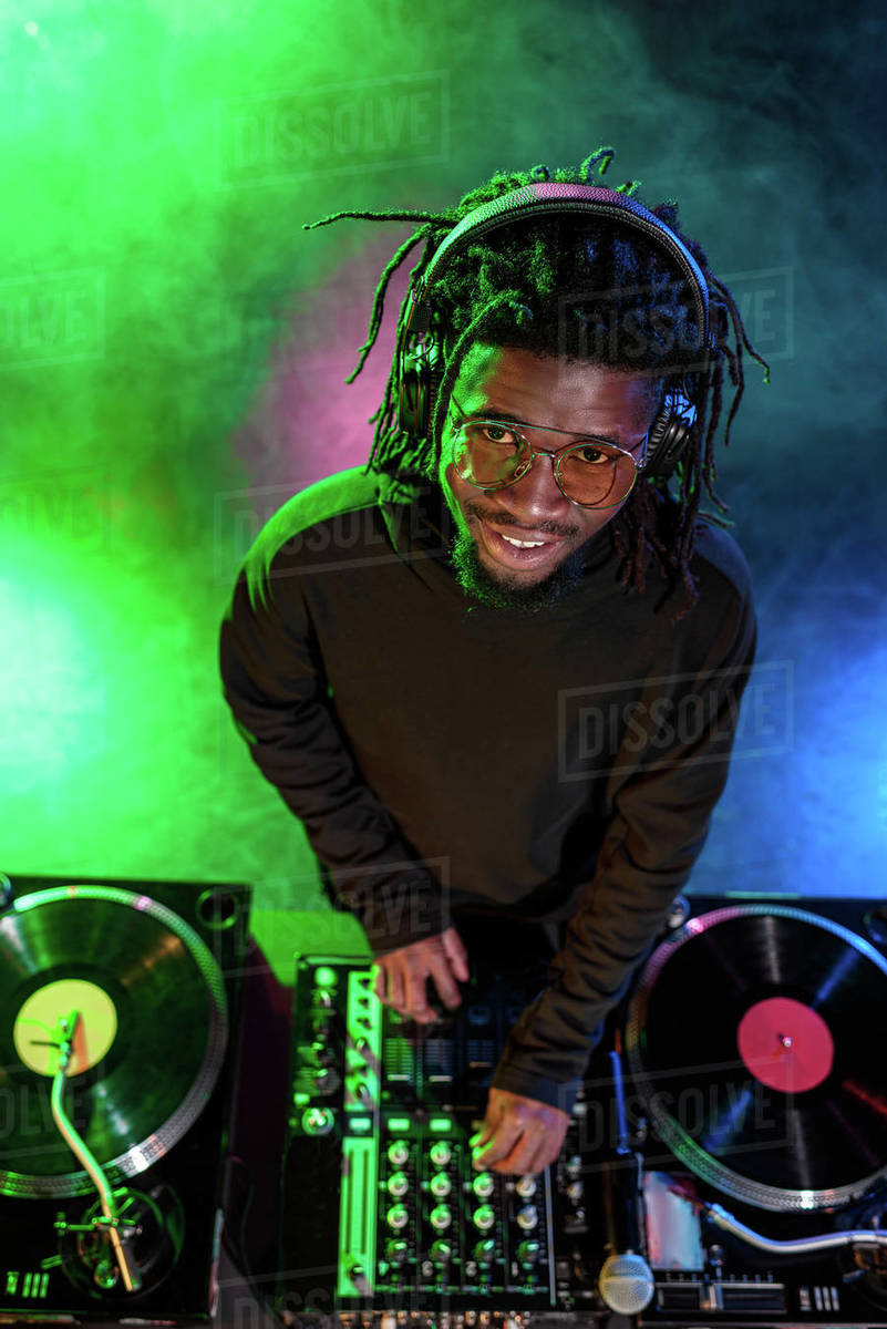 Professional African American club dj in headphones with sound mixer in ...