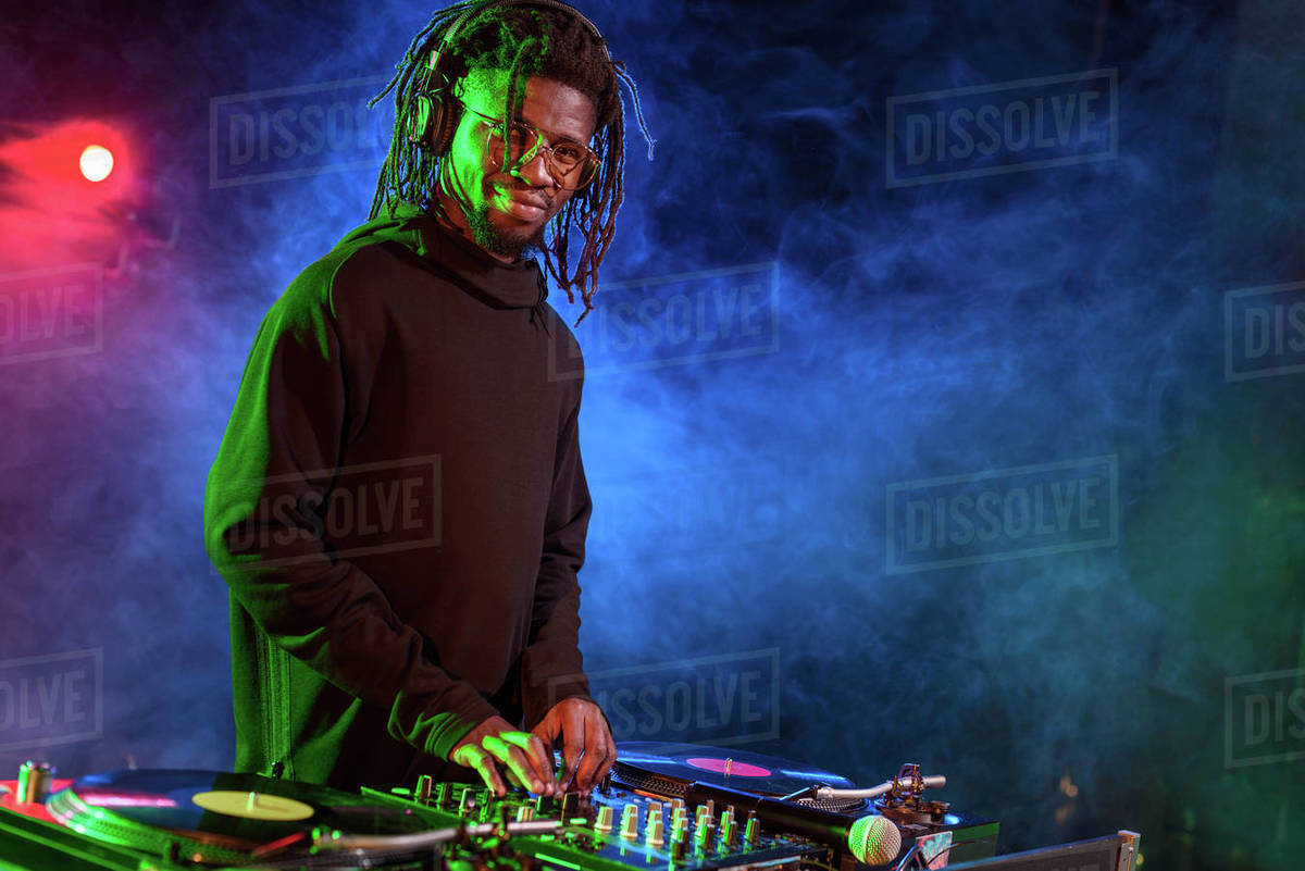 Professional African American dj in headphones with sound mixer in ...