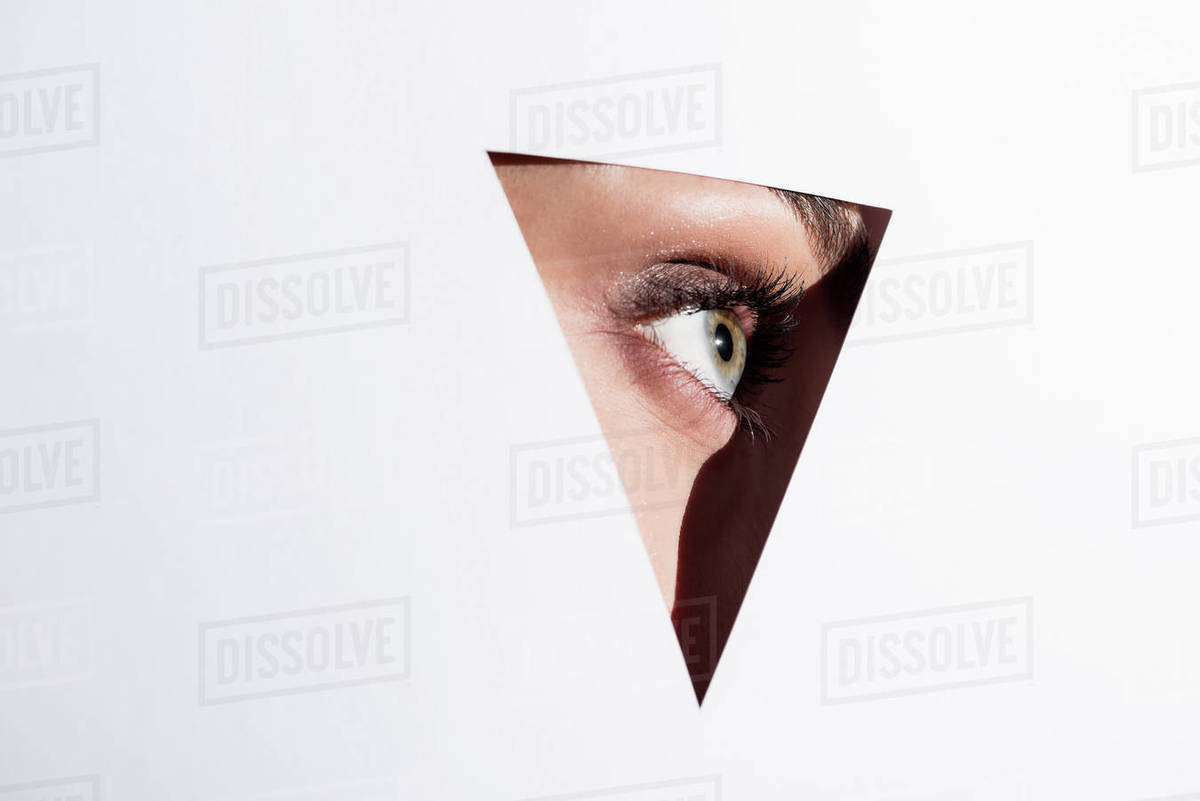 Woman looking out of hole with one eye isolated on white - Royalty-free ...