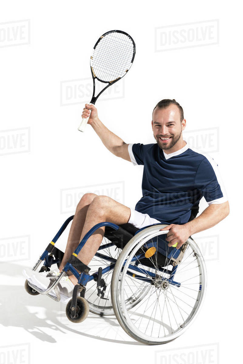 Happy young sportsman in wheelchair holding tennis racquet and smiling ...
