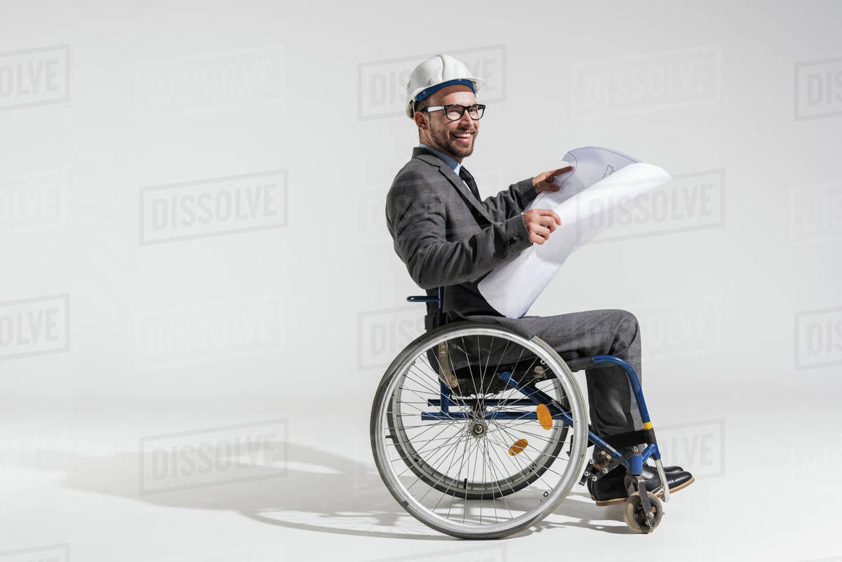 Smiling disabled architect in wheelchair holding blueprint isolated on ...