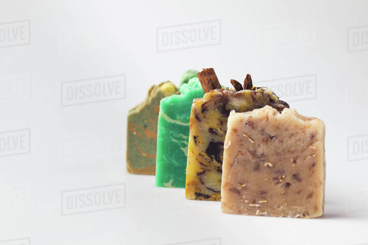 close-up shot of various handcrafted soap standing in row on white ...
