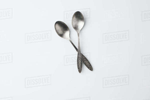 top view of crossed spoons isolated on white - Stock Photo - Dissolve