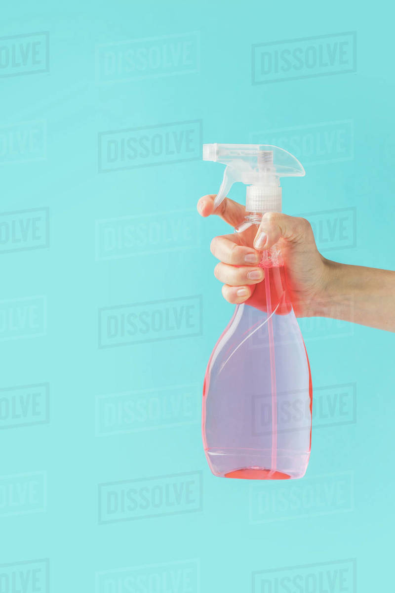 Cropped view of hand holding spray bottle, isolated on blue - Royalty ...
