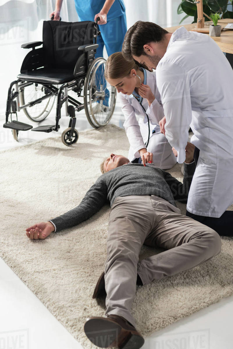 female doctor checking unconscious man palpitation with stethoscope ...