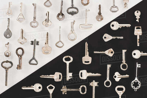 top view of different vintage keys over black and white background ...