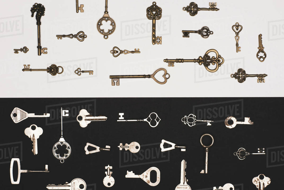 top view of different vintage keys over black and white background ...