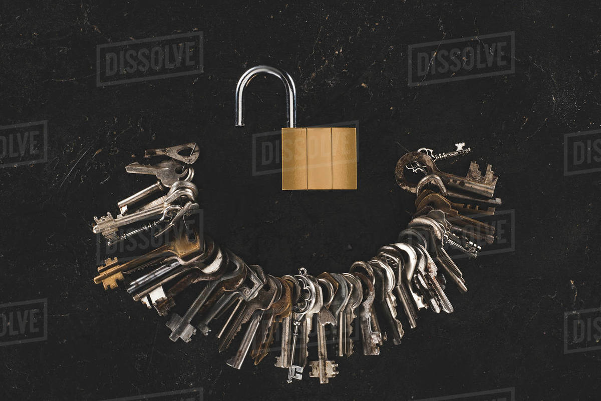 top view of heap different metal keys with opened lock isolated on ...