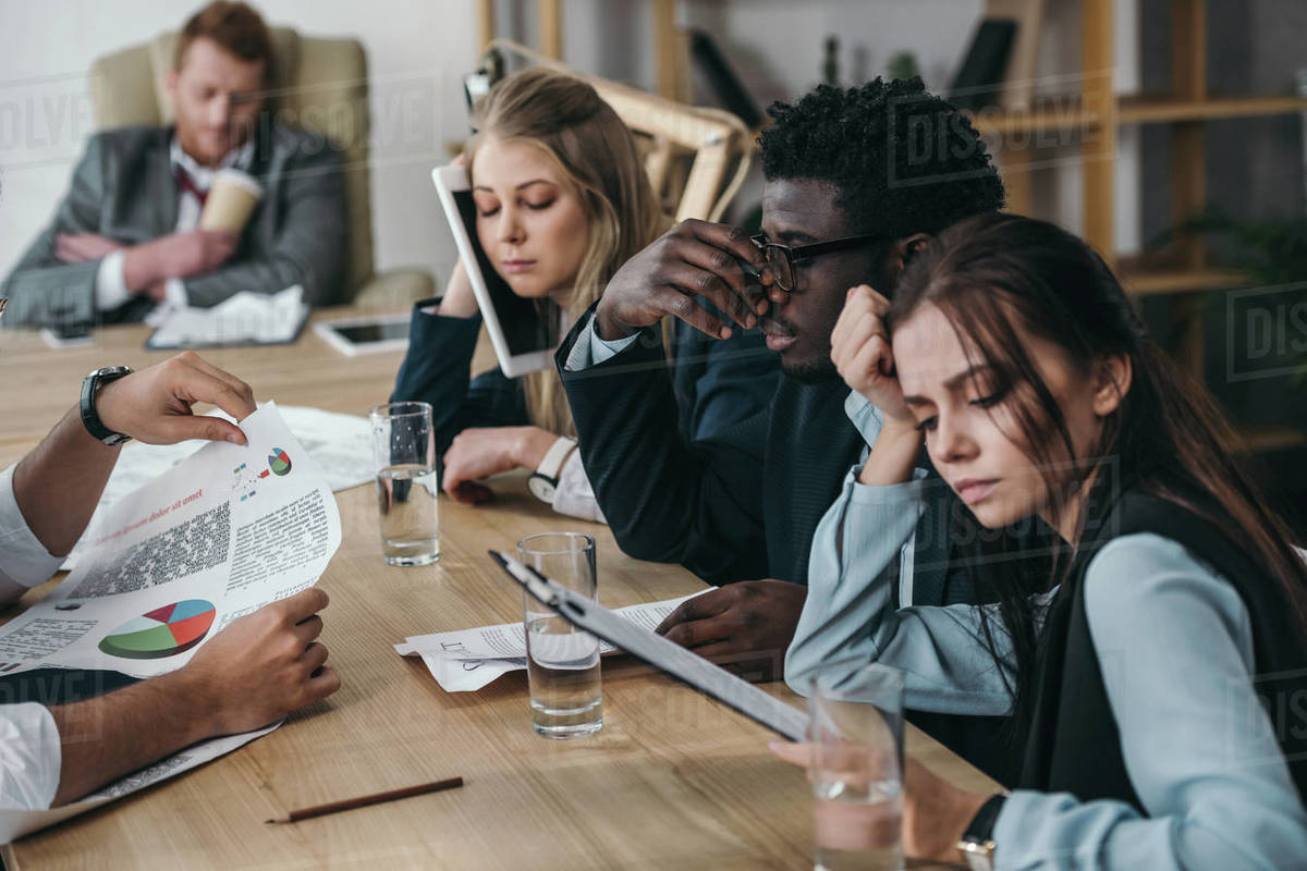exhausted zombie like businesspeople sitting in conference hall at ...