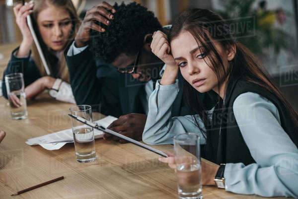 group of exhausted zombie like businesspeople sitting at office ...