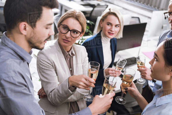 Partial view of young business team drinking champagne together after ...