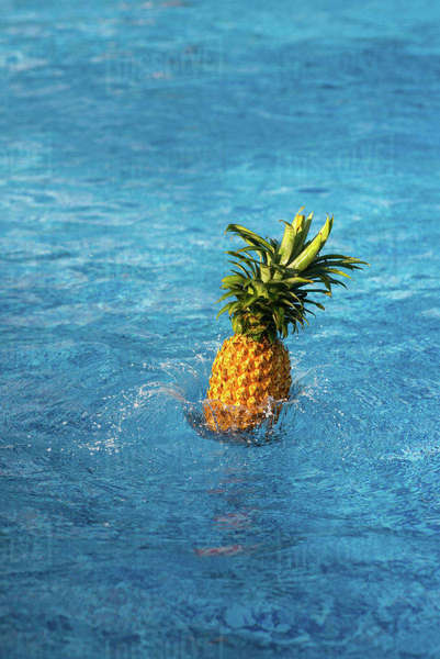 Pineapple falling in blue water of swimming pool - Royalty-free Stock ...
