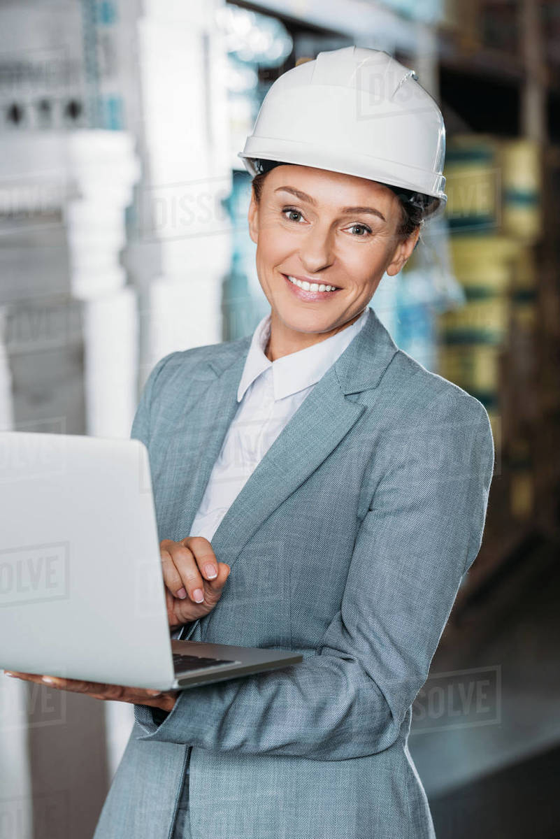 Female inspector in helmet with laptop in warehouse - Stock Photo ...