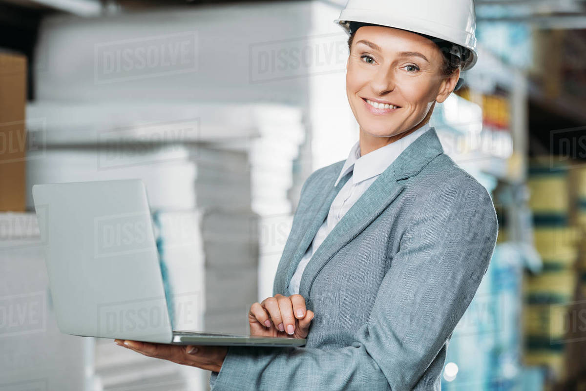 Female inspector in helmet with laptop in warehouse - Stock Photo ...