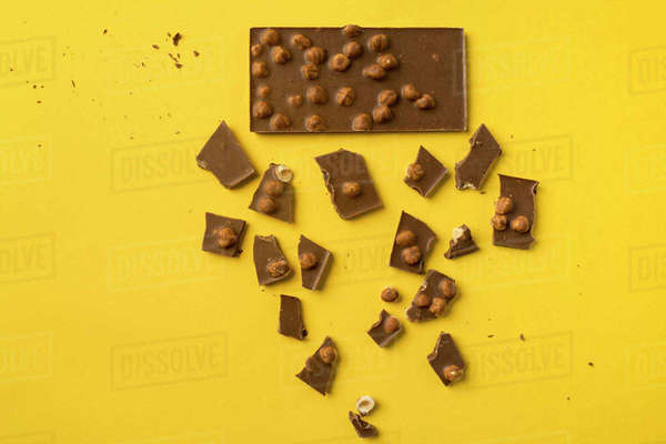 Top view of Milk Chocolate bar with scattered pieces isolated on yellow ...