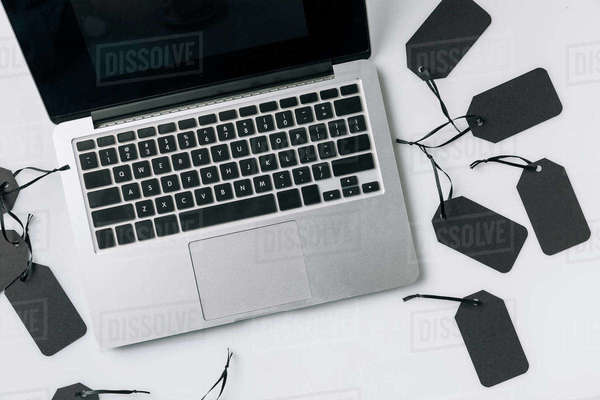 Close-up view of laptop with black screen and blank labels on white ...