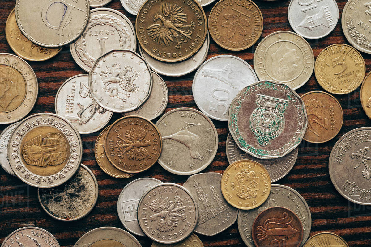 Top view of collection of coins on wooden tabletop - Stock Photo - Dissolve