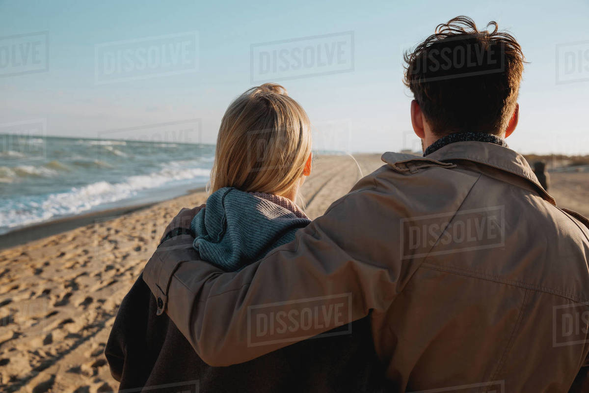 Back view of couple hugging and spend time together at seaside in ...