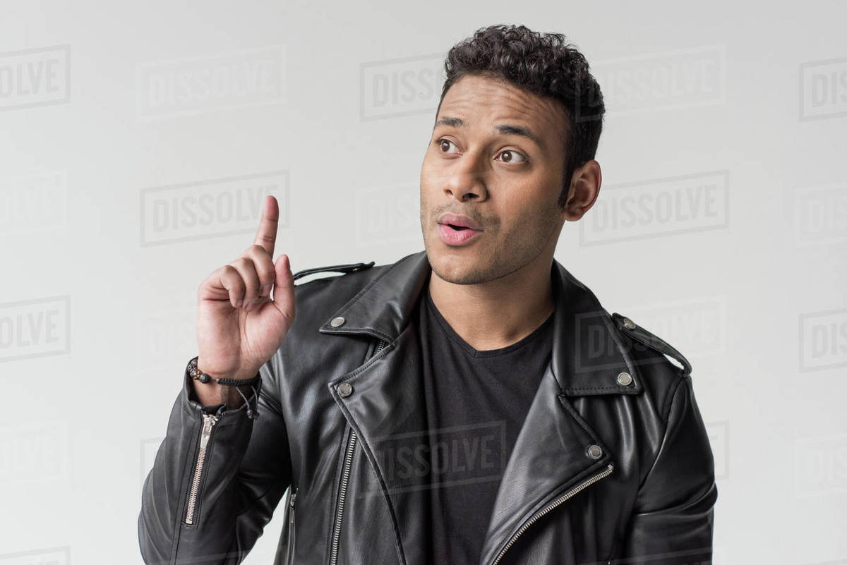 Portrait of young african american man pointing up isolated on grey ...