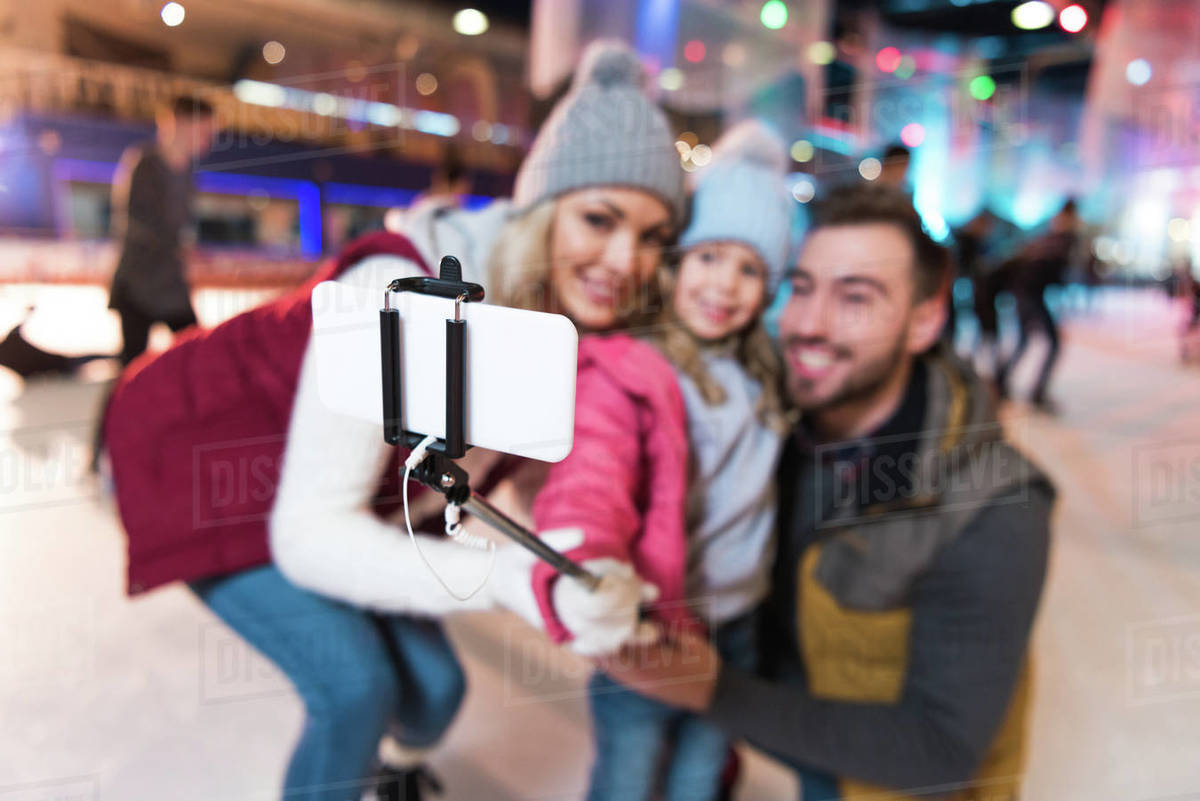 Selective focus of happy young family taking selfie with smartphone on ...